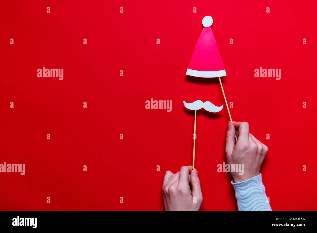 Hands holding Santa Claus Christmas photobooth props on a red ...