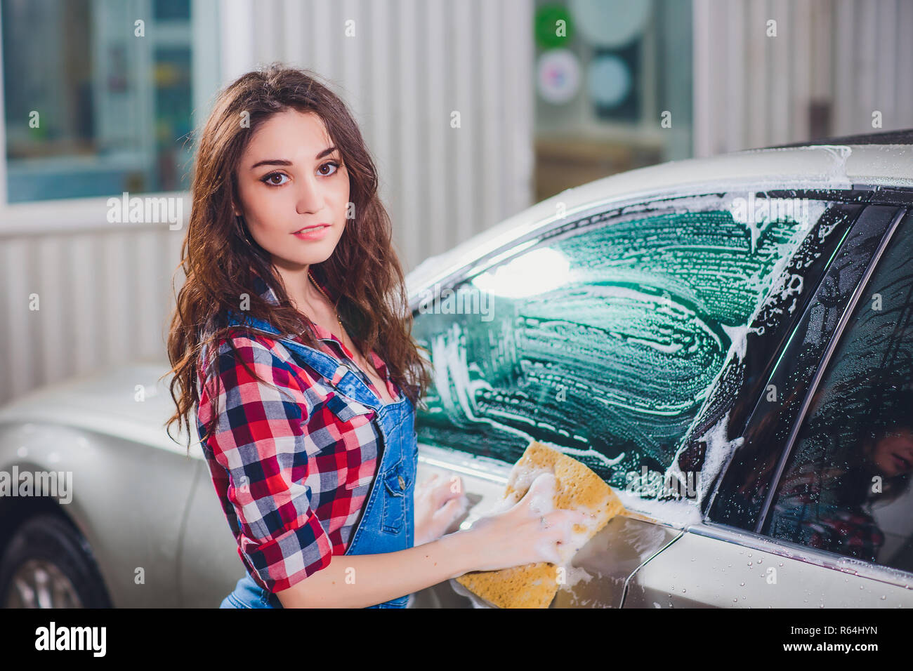 outdoor car wash with yellow sponge. Beautiful girl washes car Stock ...