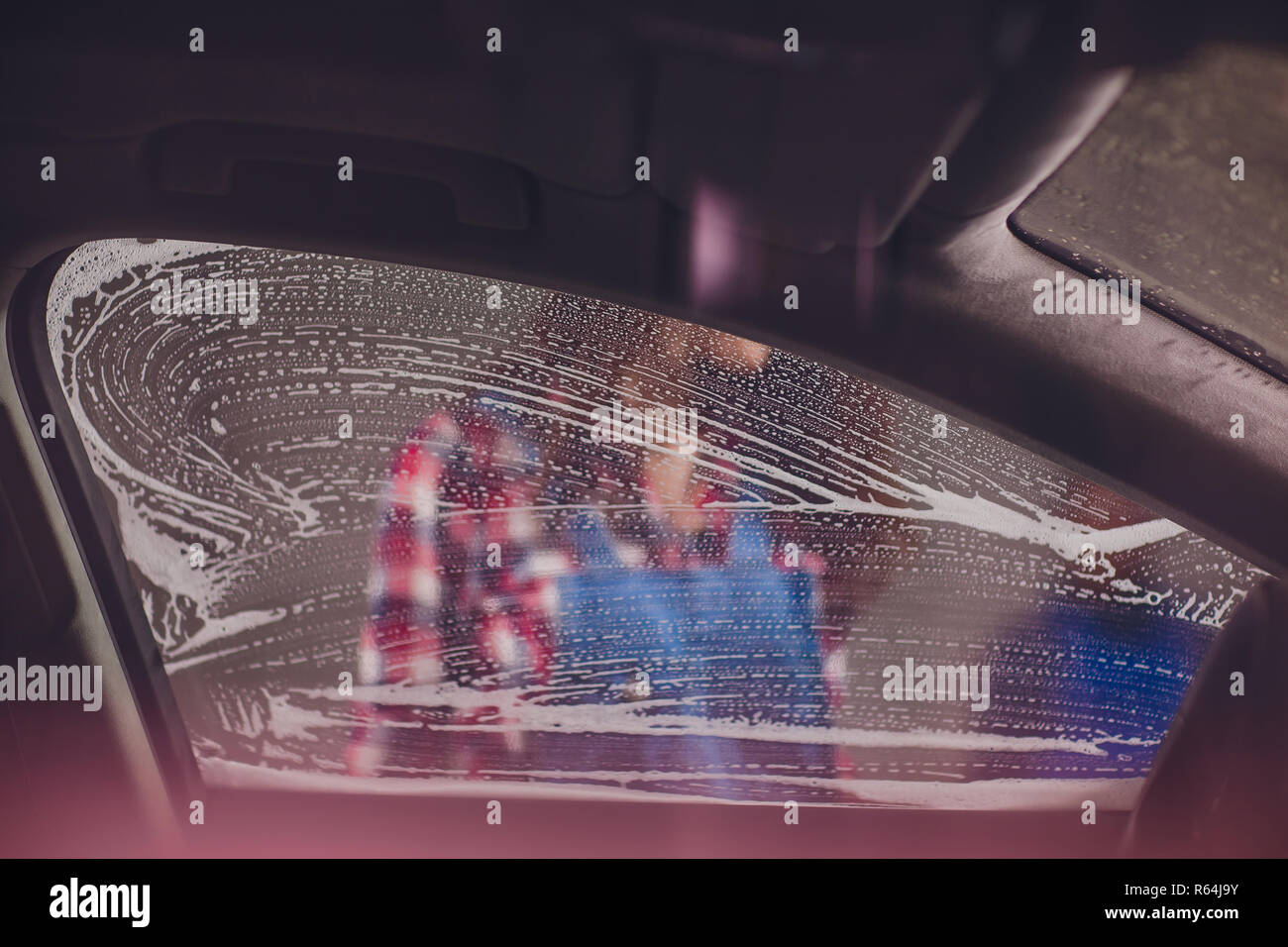 Elementary girl washing car window viewed from inside car Stock Photo ...