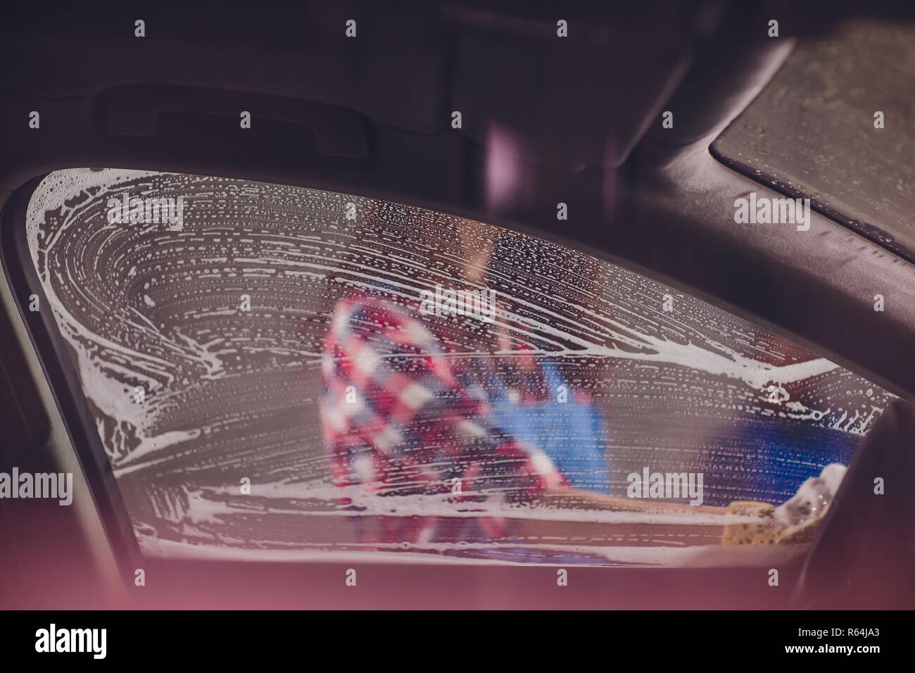 Elementary girl washing car window viewed from inside car Stock Photo ...