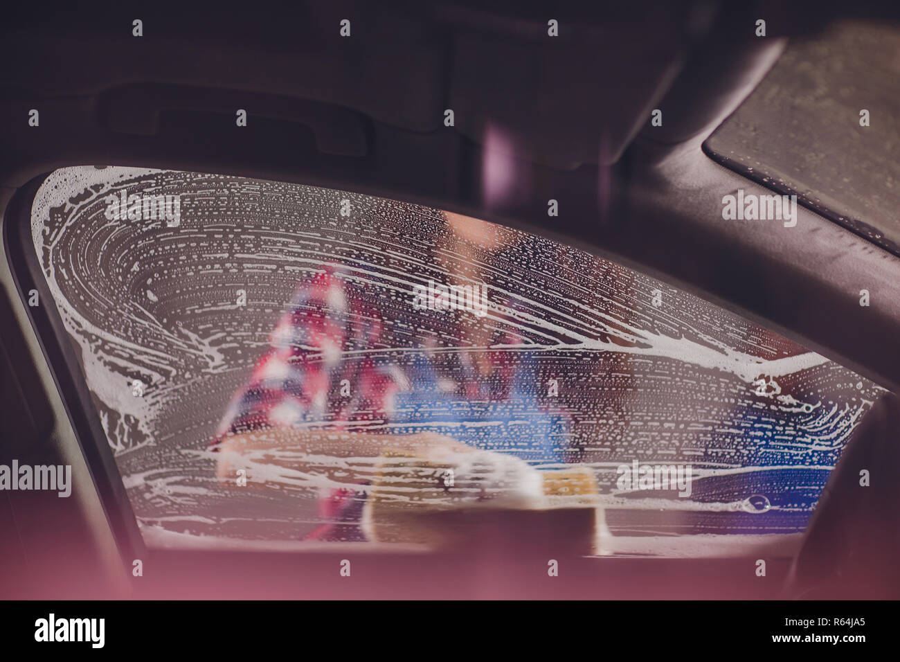 Elementary girl washing car window viewed from inside car Stock Photo ...