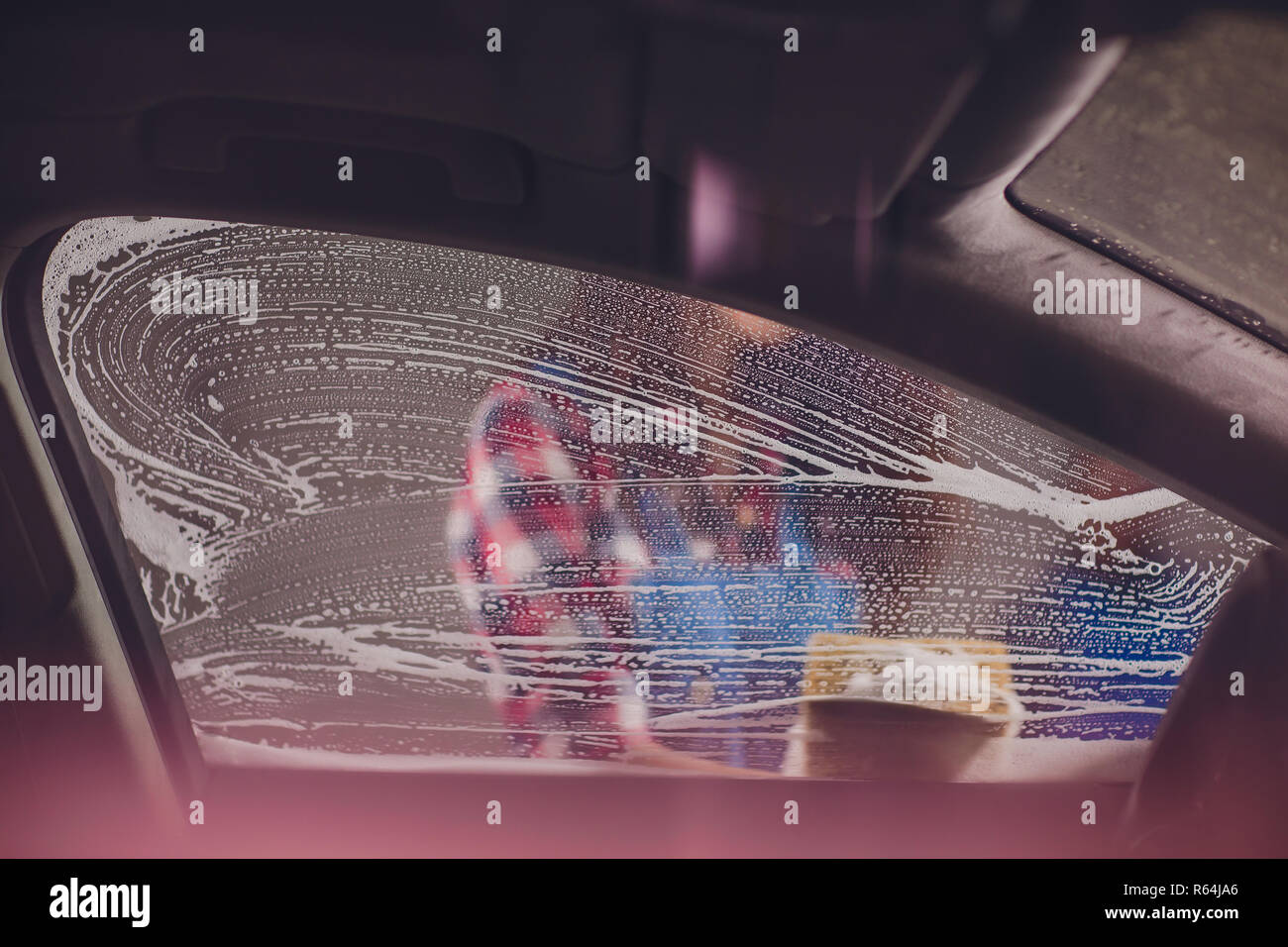 Elementary girl washing car window viewed from inside car Stock Photo ...