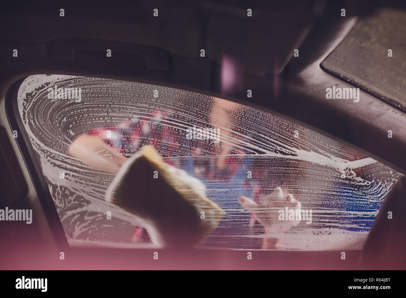 Elementary girl washing car window viewed from inside car Stock Photo ...