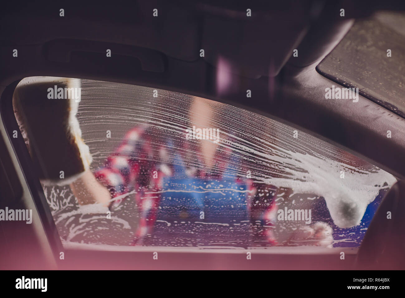 Elementary girl washing car window viewed from inside car Stock Photo ...
