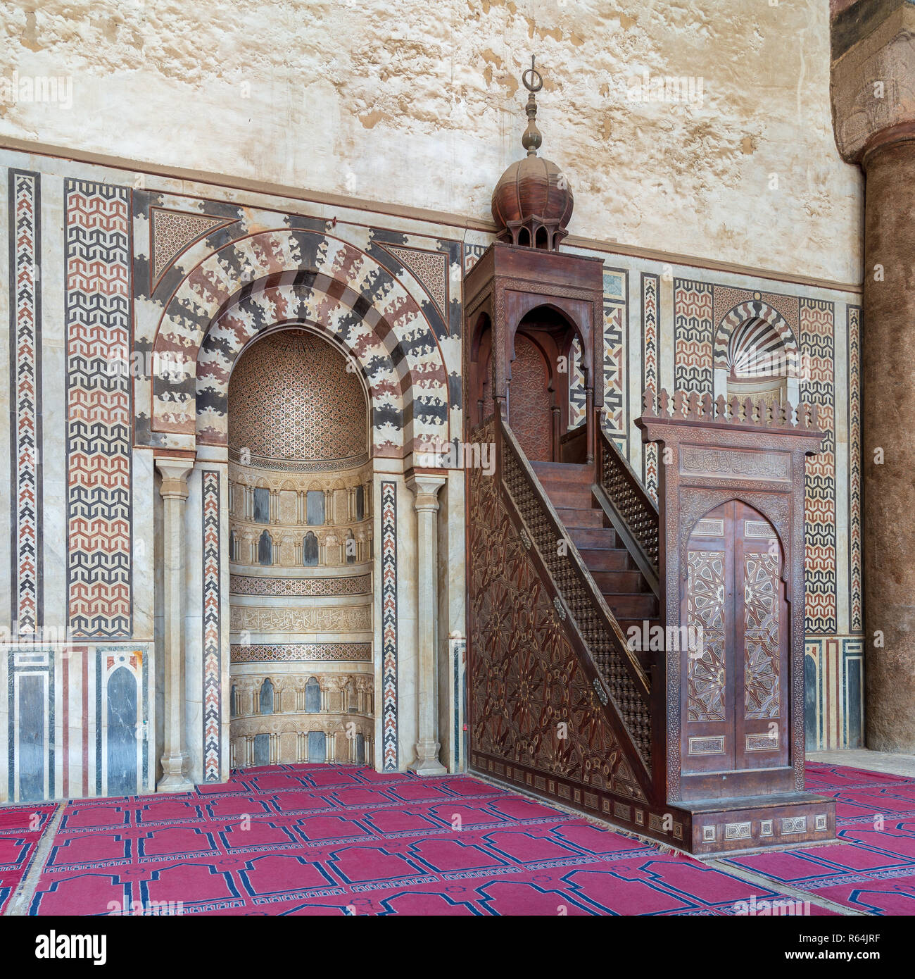 Colorful decorated marble wall with engraved niche (Mihrab) and wooden ...