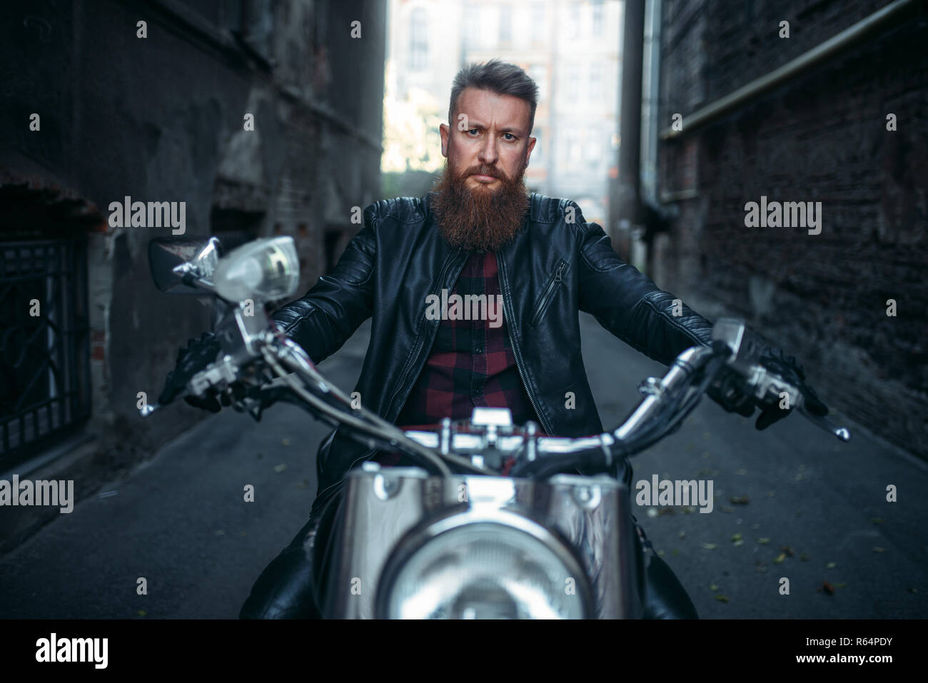 Bearded biker in leather jacket sitting on classical chopper, front ...