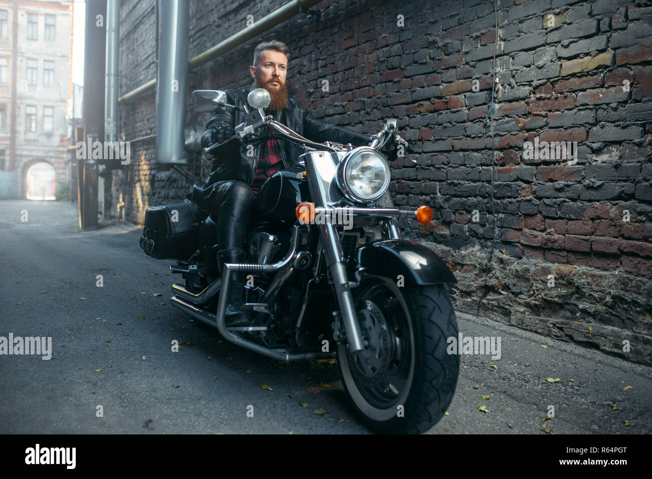 Bearded motorcyclist poses on classical chopper, biker. Vintage bike ...