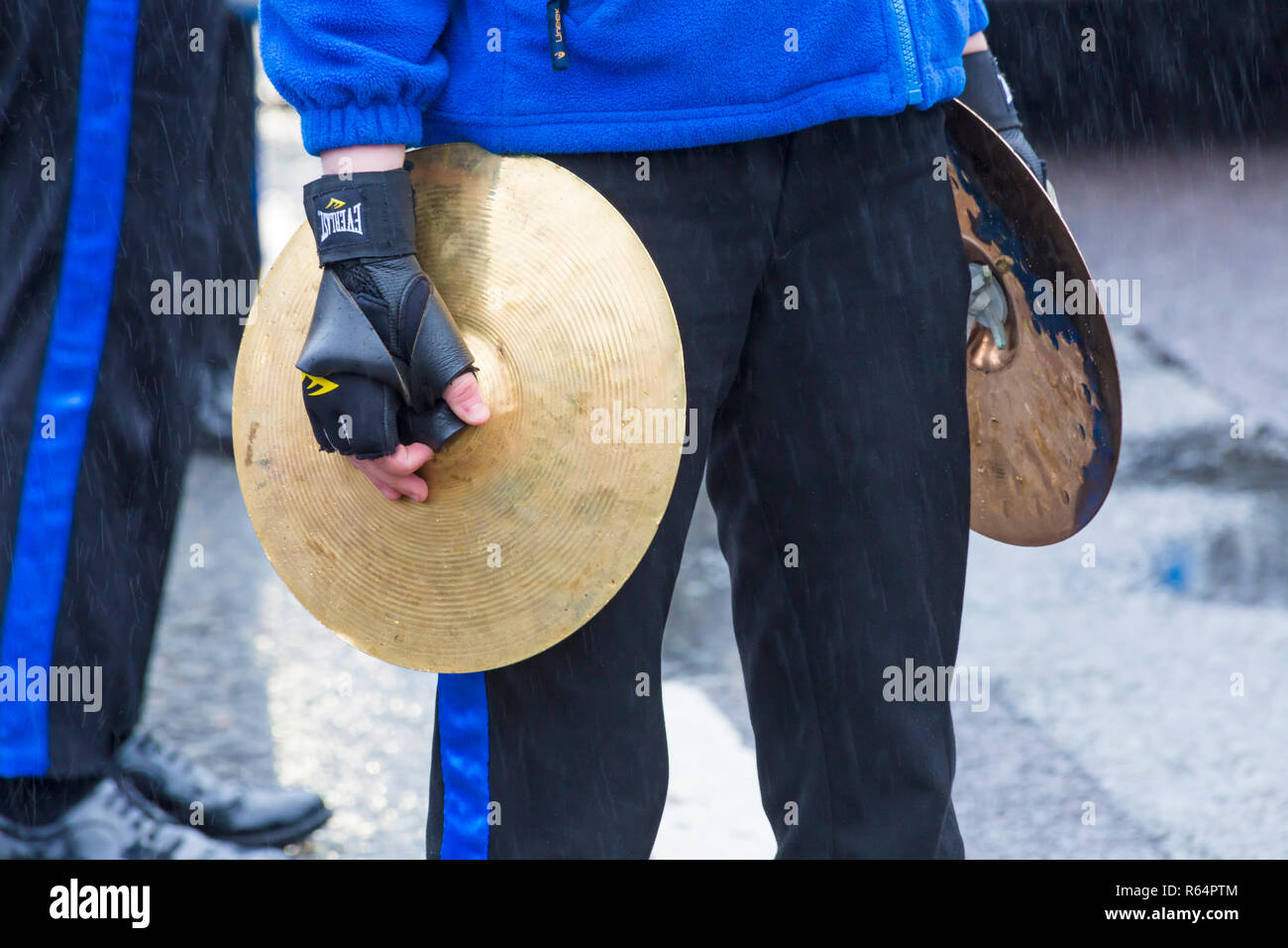 Holding cymbals in the rain, member of The Dolphin Marching Band at ...
