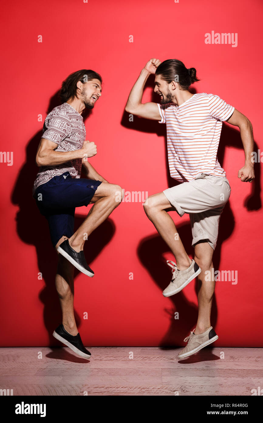 Full length portrait of a two young happy twin brothers isolated over ...