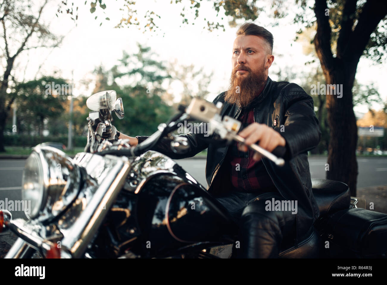 Biker sitting on a motorcycle, classical chopper. Vintage bike, rider ...
