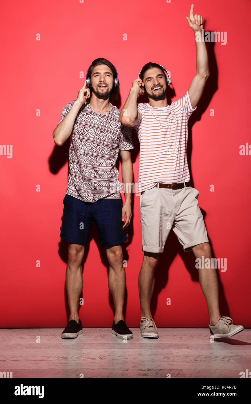 Full length portrait of a two young cheerful twin brothers isolated ...