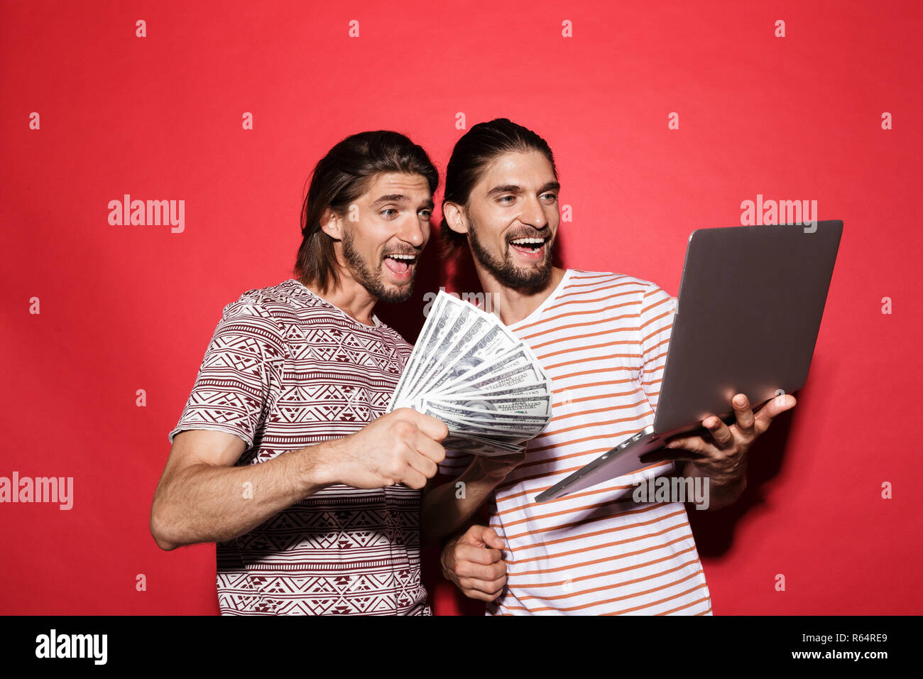 Portrait of a two young happy twin brothers isolated over red ...