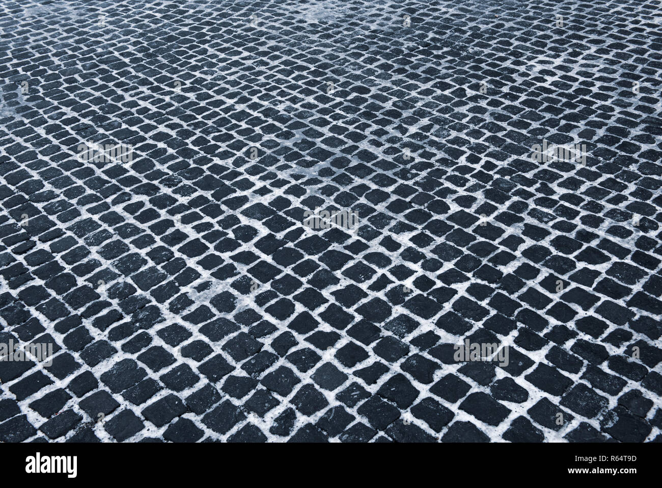 Black Cobblestone pavement in Winter with snow Stock Photo - Alamy
