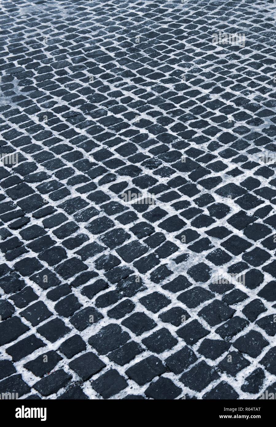 Black Cobblestone pavement in Winter with snow Stock Photo - Alamy