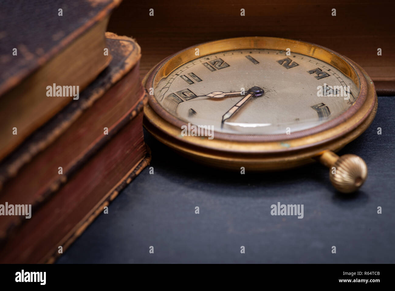 Panta rhei concept: antique pocket watch and pile of vintage hard cover ...