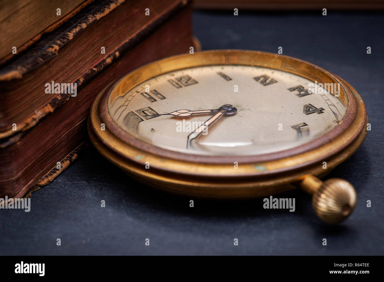 Panta rhei concept: antique pocket watch and pile of vintage hard cover ...