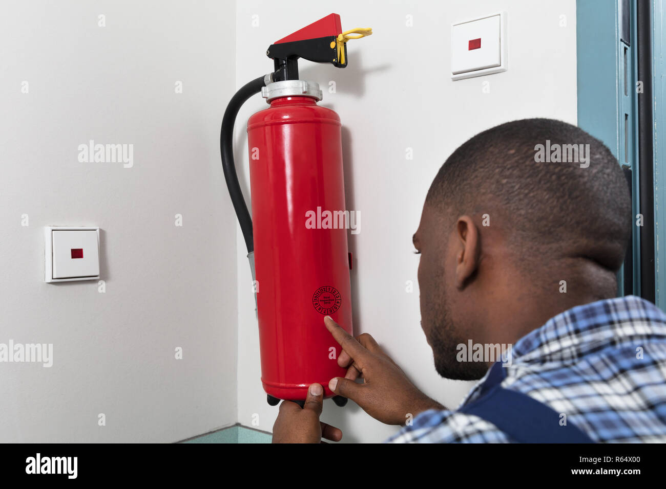 Male Professional Checking A Fire Extinguisher Stock Photo - Alamy