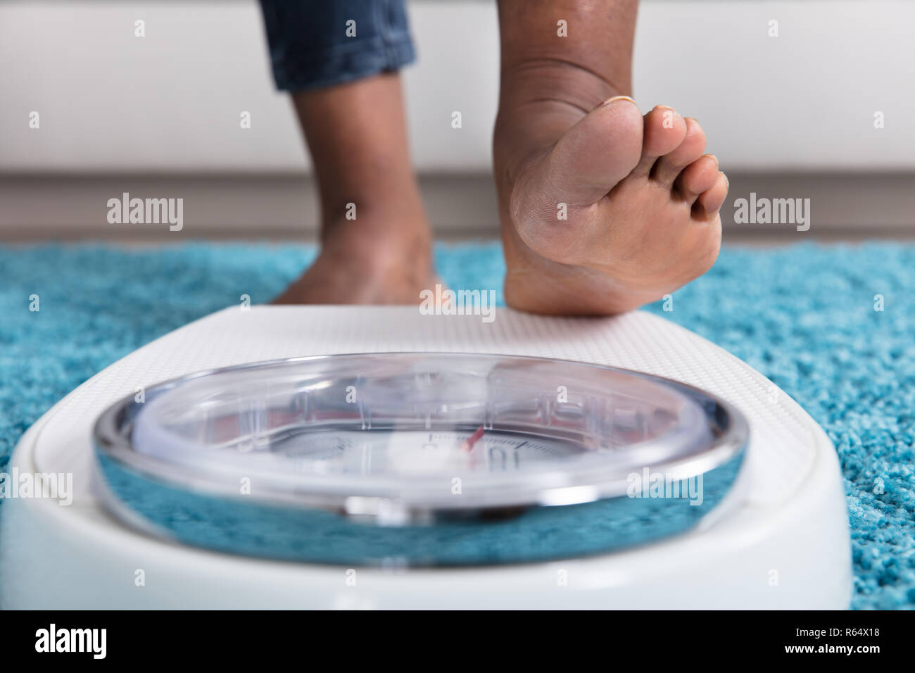 Human Foot Stepping On Weighing Scale Stock Photo - Alamy