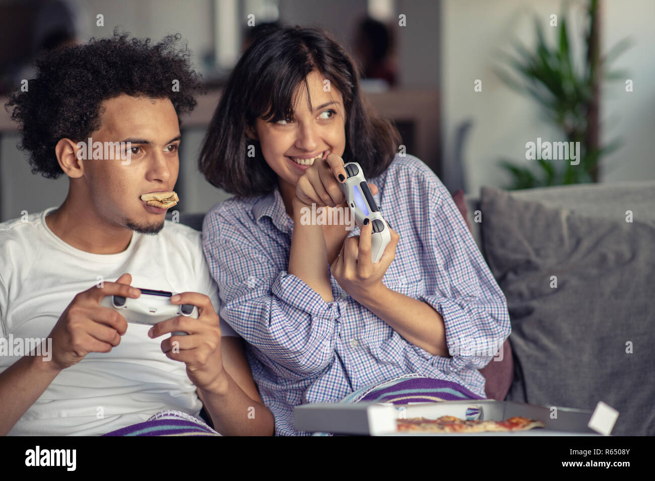 Image of young loving couple in kitchen at home indoors. Eating pizza ...