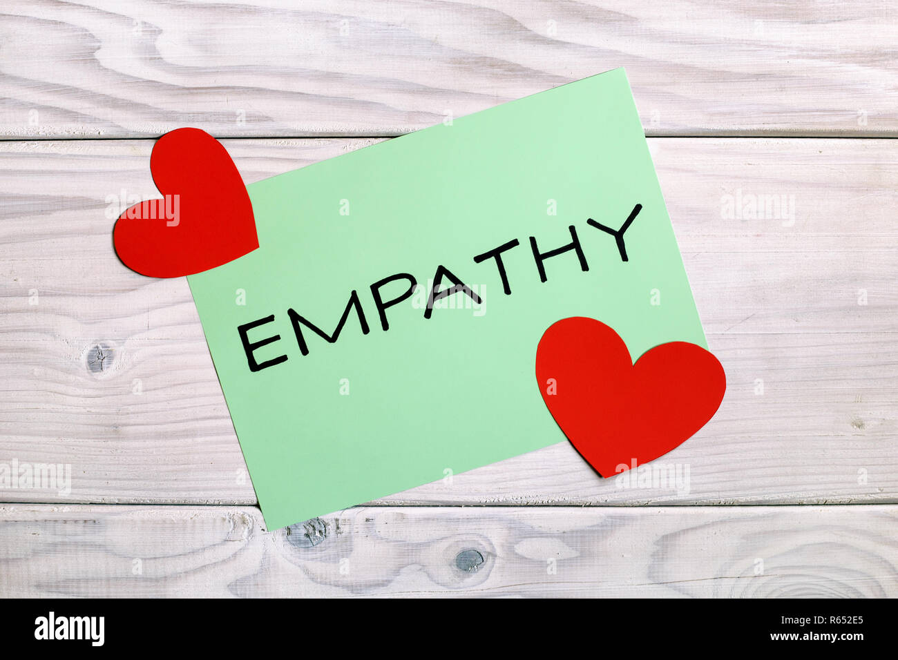 Word empathy and heart shapes on wooden table Stock Photo - Alamy