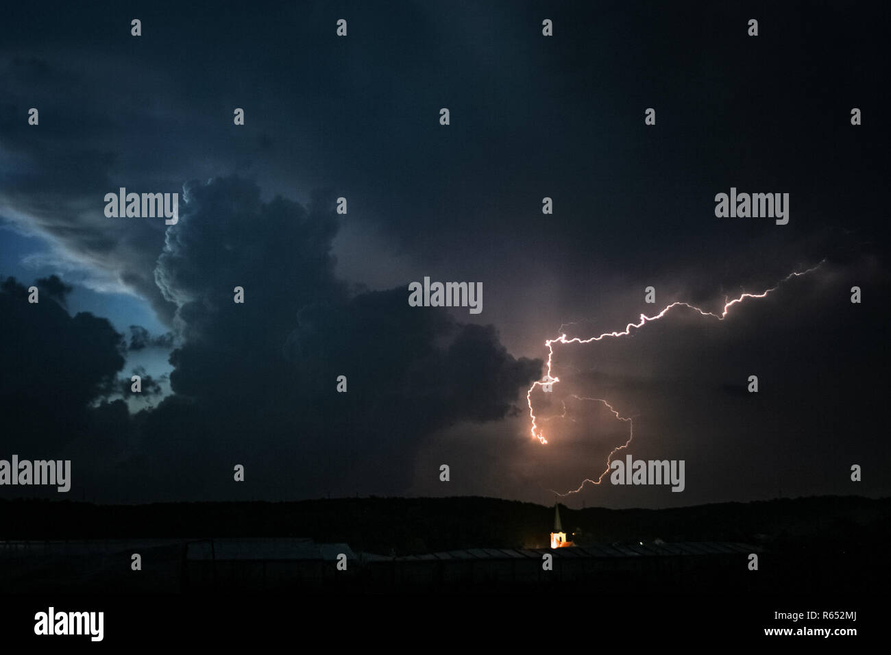 Clouds and lightning over a church and village in Transylvania, Romania ...