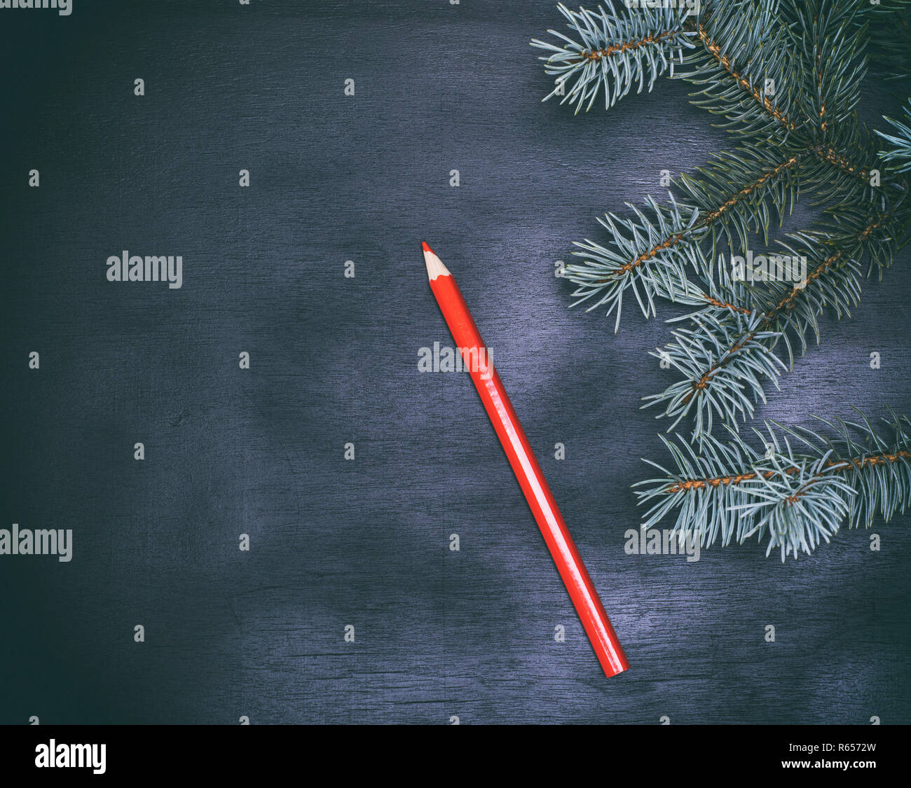 red wooden pencil and a green twig of a fir tree Stock Photo - Alamy