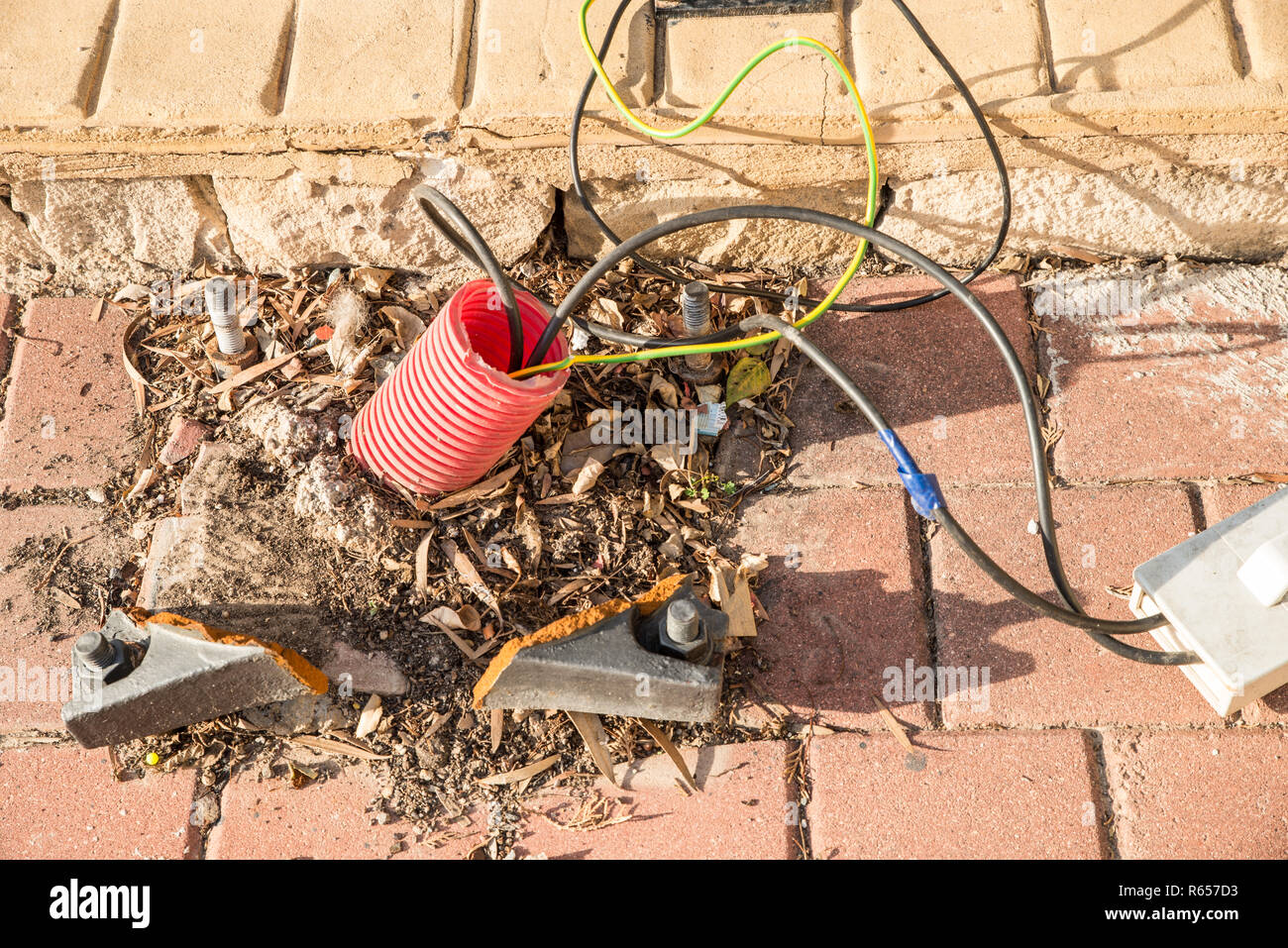 Loose electricity wires sticking out of the pavement in a public park ...
