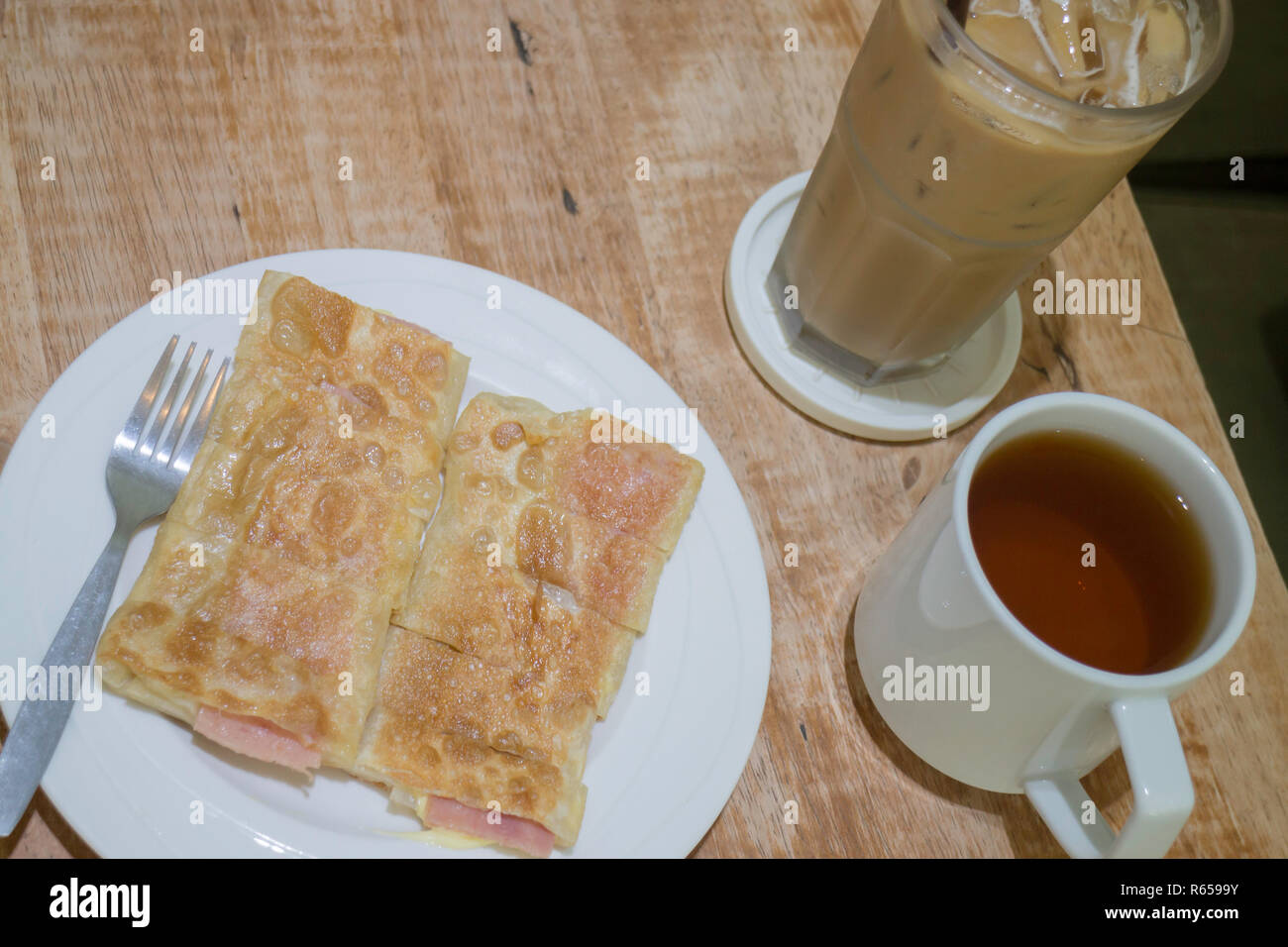 Breakfast set of coffee drink and fried ham cheese roti Stock Photo - Alamy
