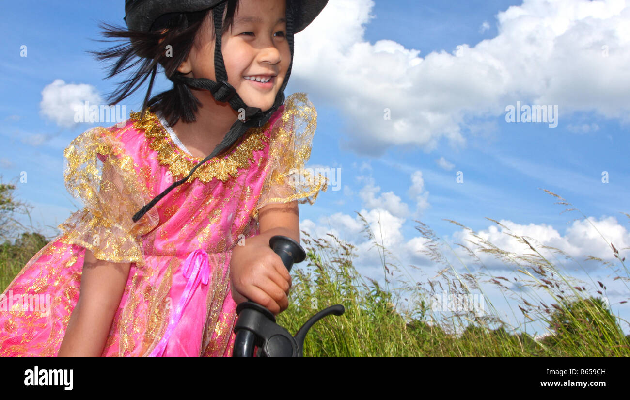Cute girl cycling with a princess outfit in denmark Stock Photo - Alamy