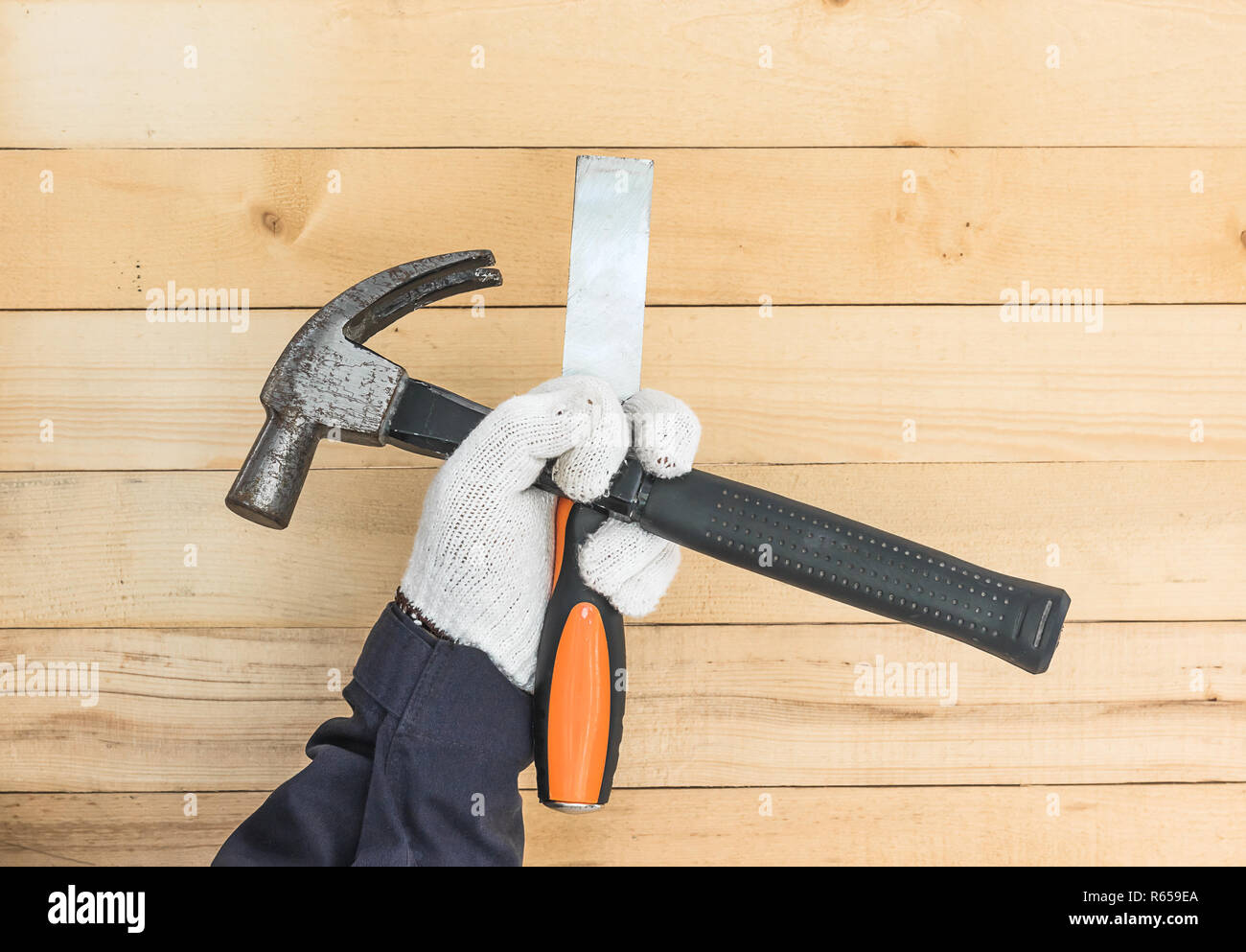 Hand in glove holding chisel and hammer Stock Photo - Alamy