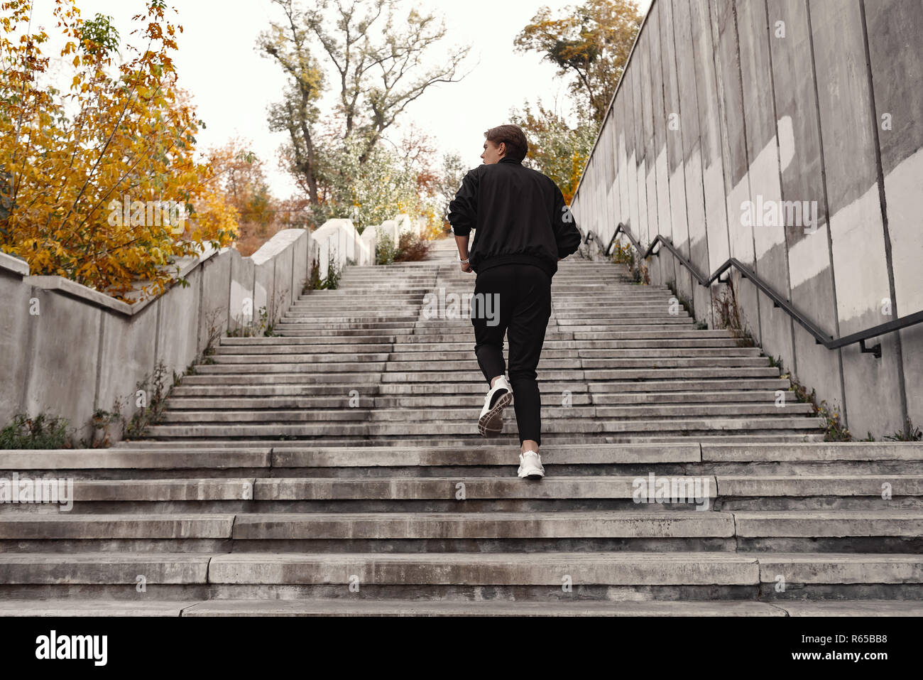 Sporty young man is running upstairs outdoors Stock Photo - Alamy