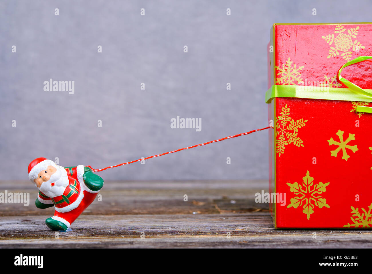 little santa claus pulling big gift box Stock Photo - Alamy