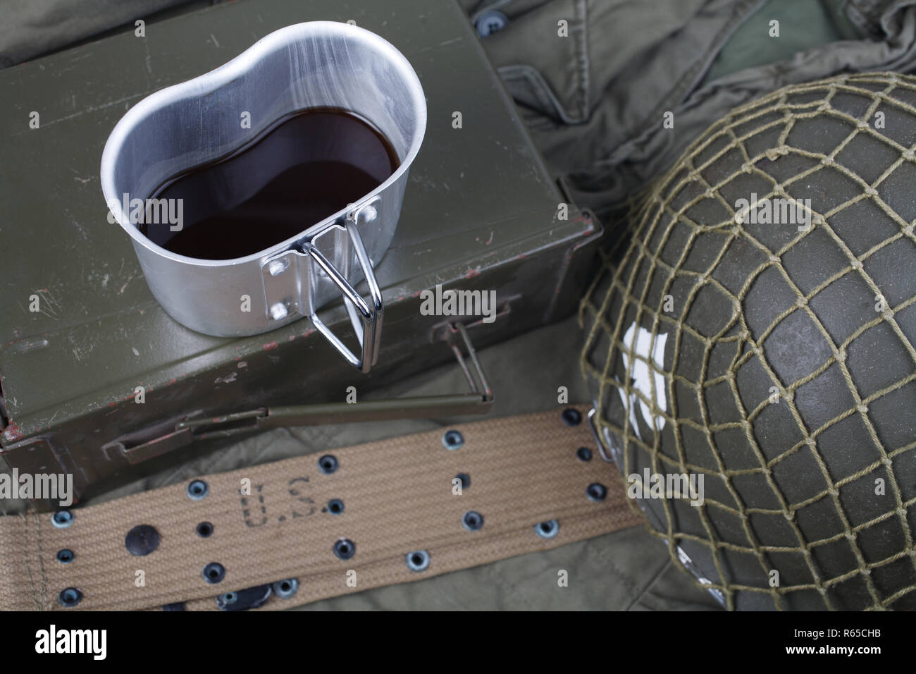 a cup of coffee with ww2 period us army military equipment on green ...