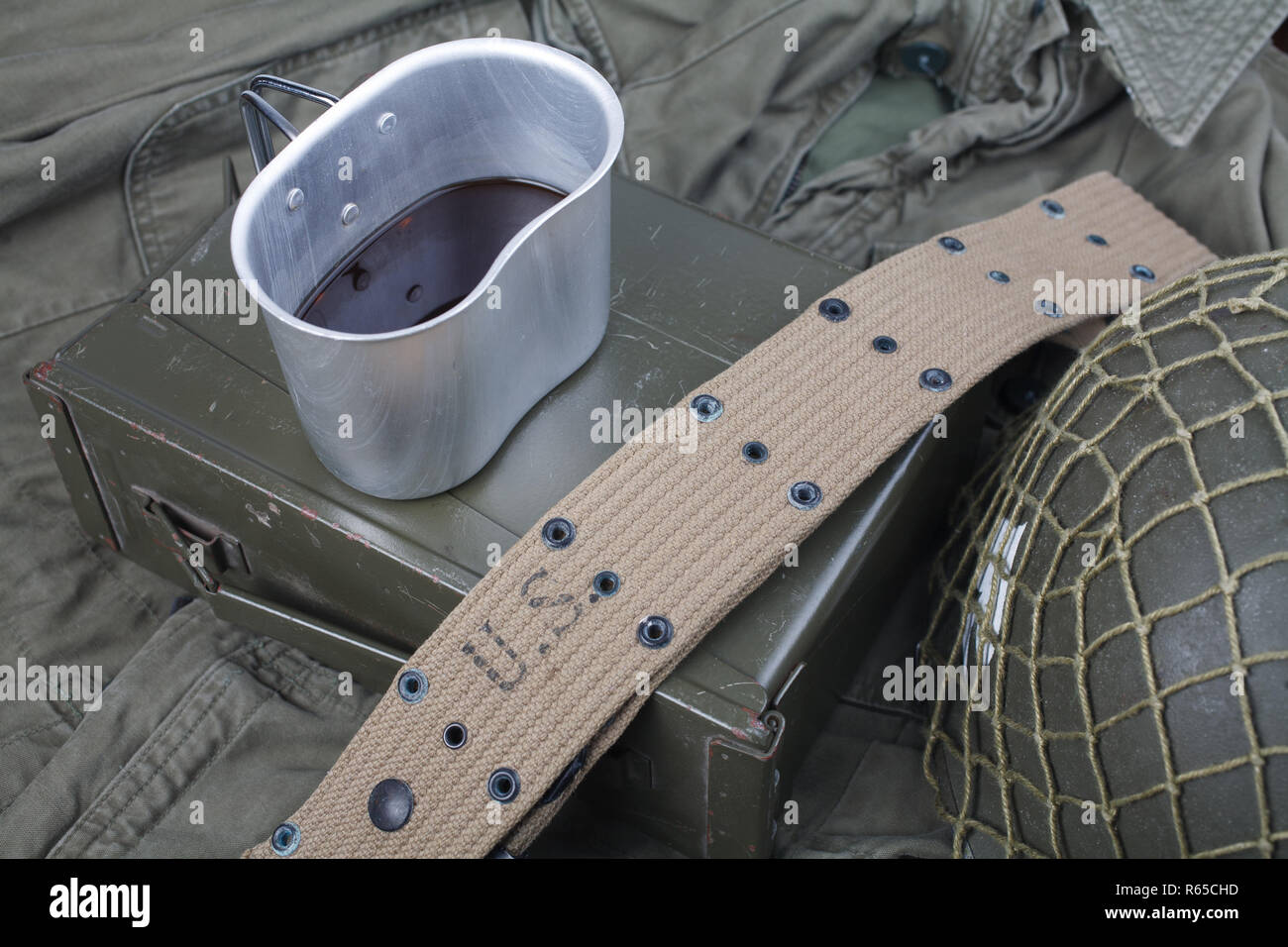 a cup of coffee with ww2 period us army military equipment on green ...