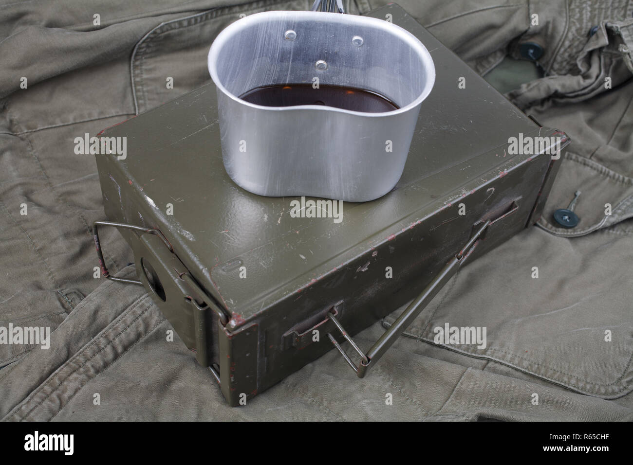 a cup of coffee with ww2 period us army military equipment on green ...