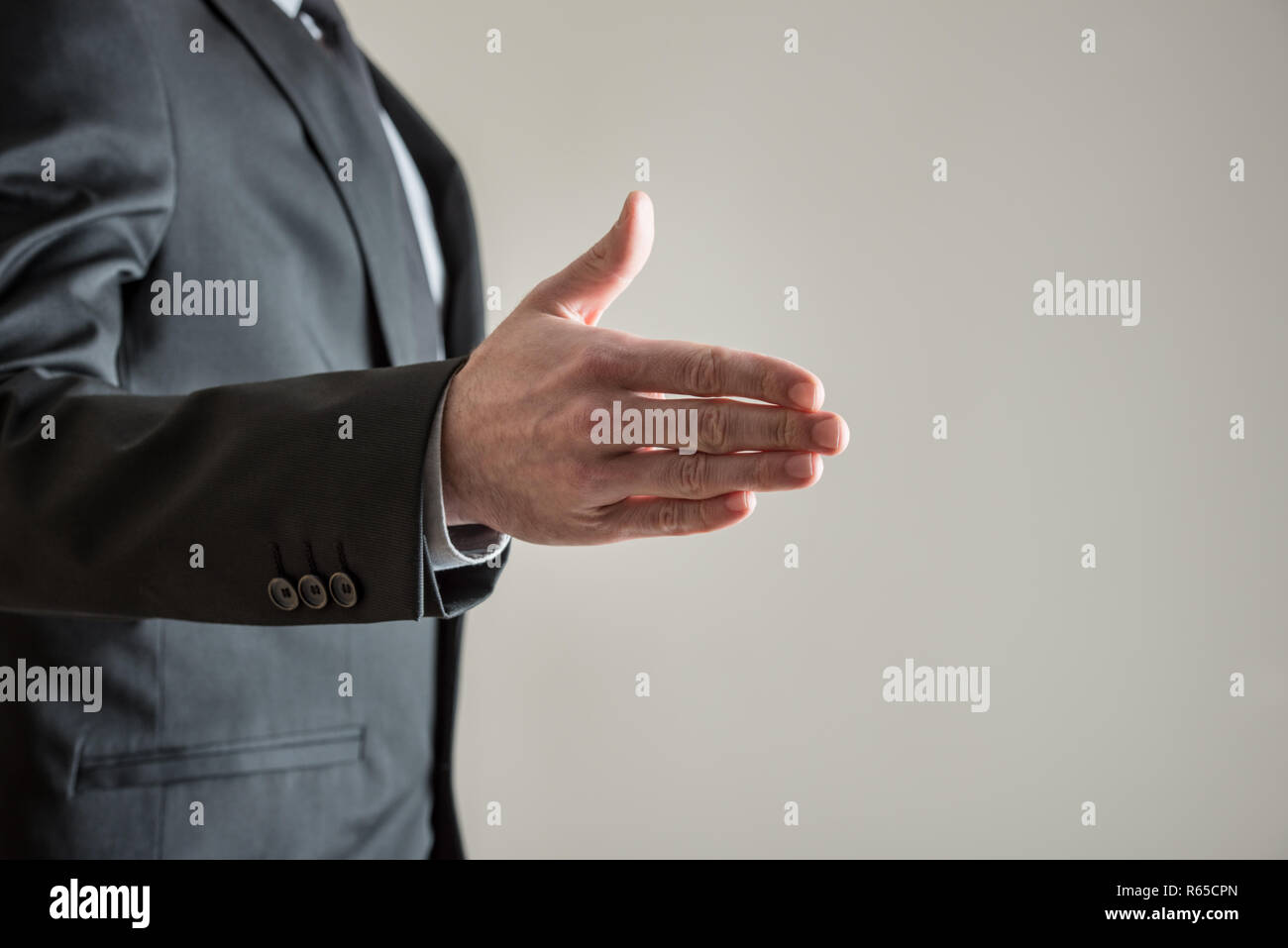 Businessman standing to the left side of the image offering his hand in ...