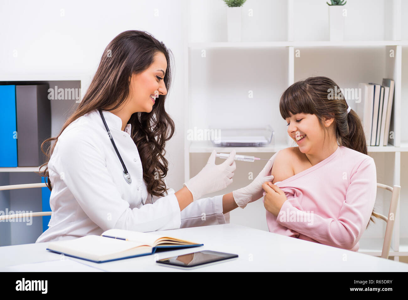 Female doctor giving injection to a child at medical office Stock Photo ...