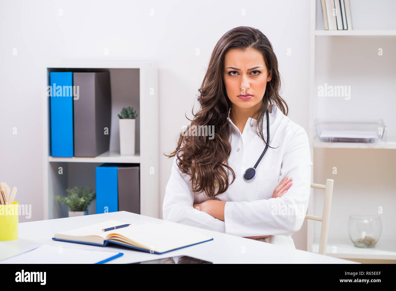 Angry female doctor looking at documents while working at her office ...