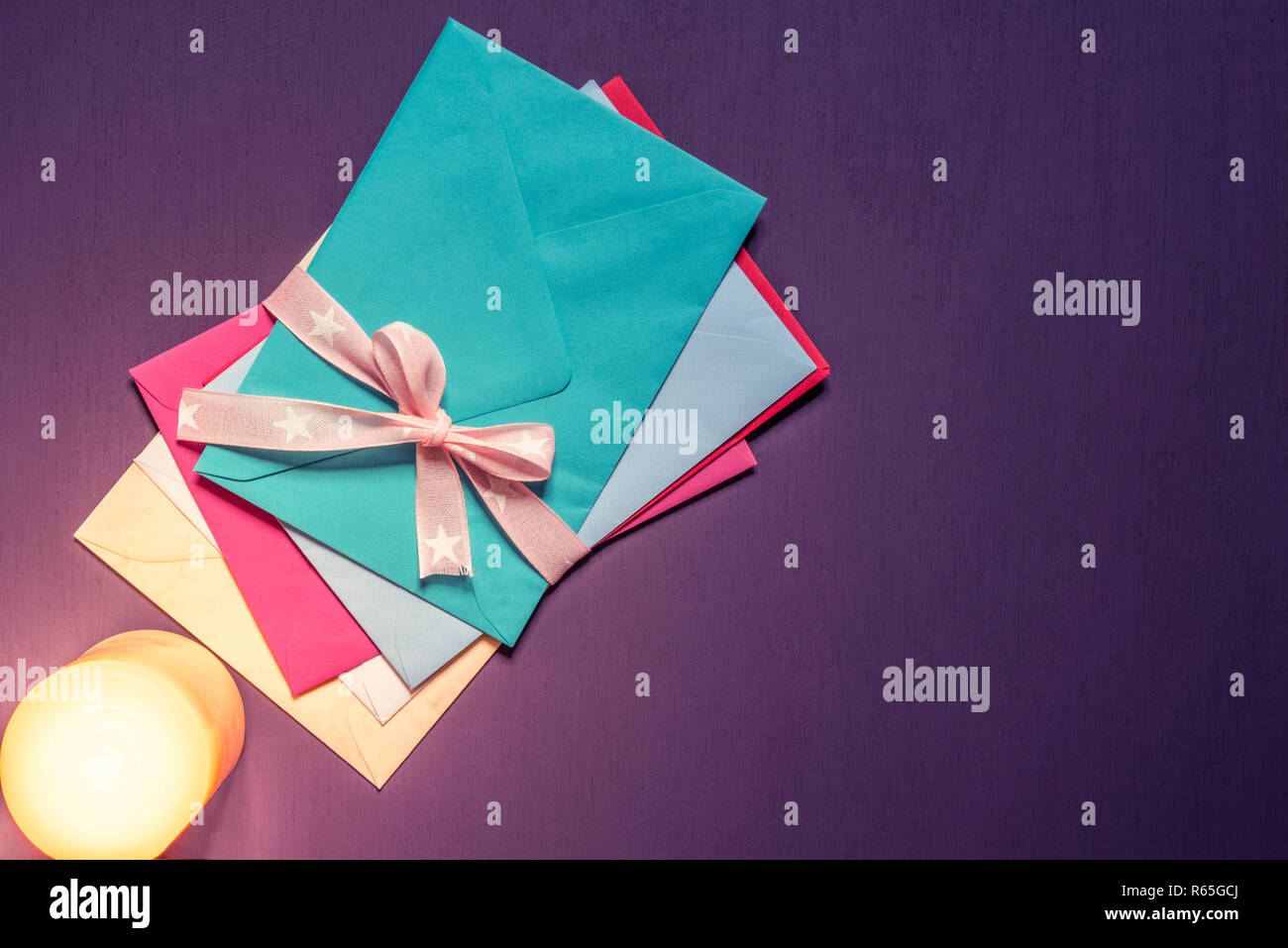 Stack of envelopes tied with bow in candlelight Stock Photo - Alamy