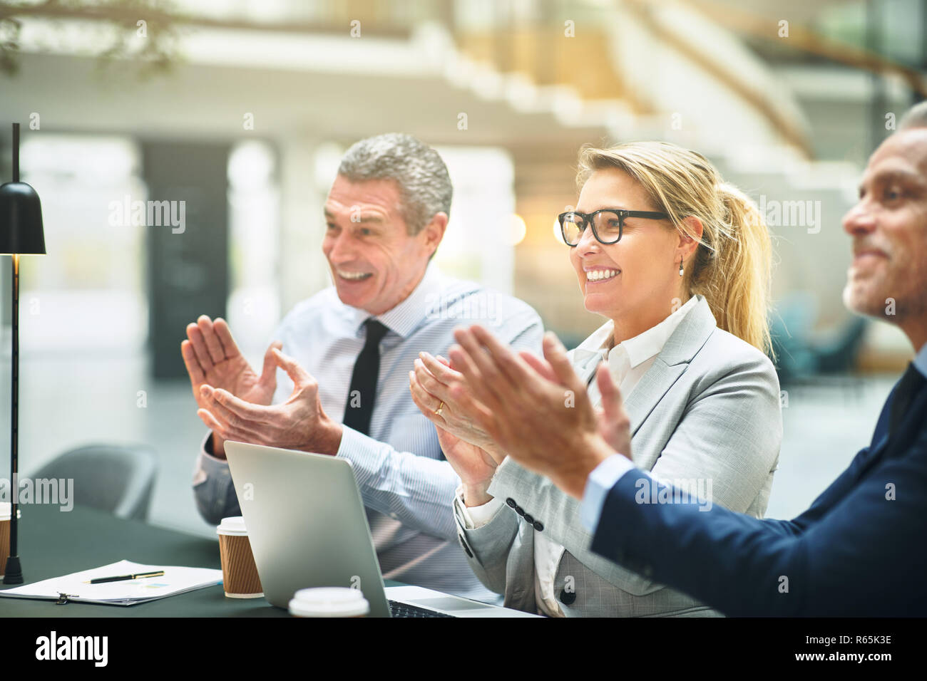 Smiling group of mature businesspeople sitting together at a table in a ...