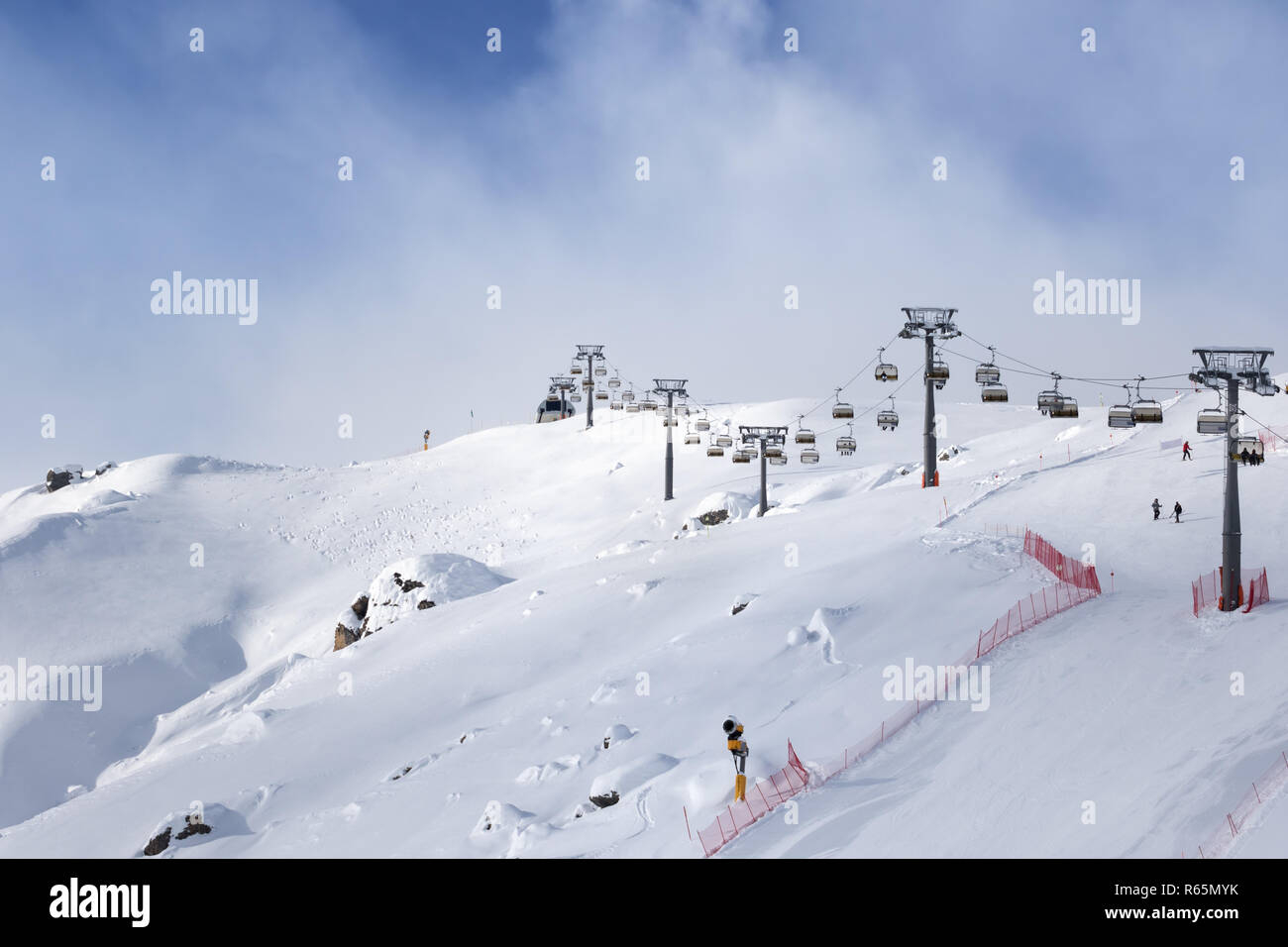Snowy ski slope and ski-lift at ski resort at sunny winter evening ...
