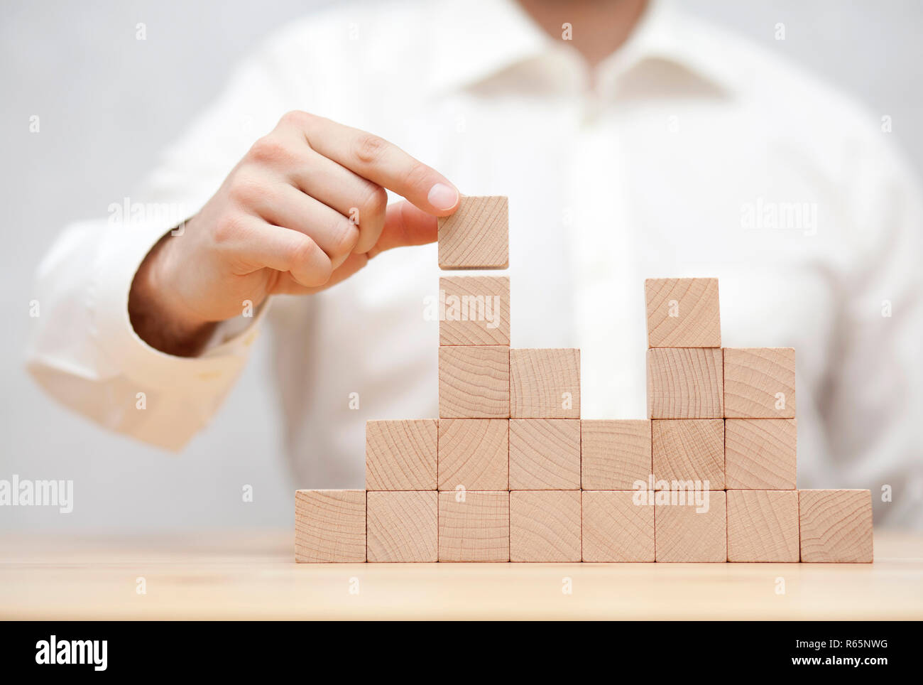 Mans hand stacking wooden hi-res stock photography and images - Alamy