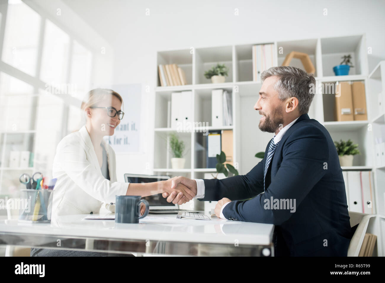 Happy business partners making handshake as symbol of cooperatio Stock ...