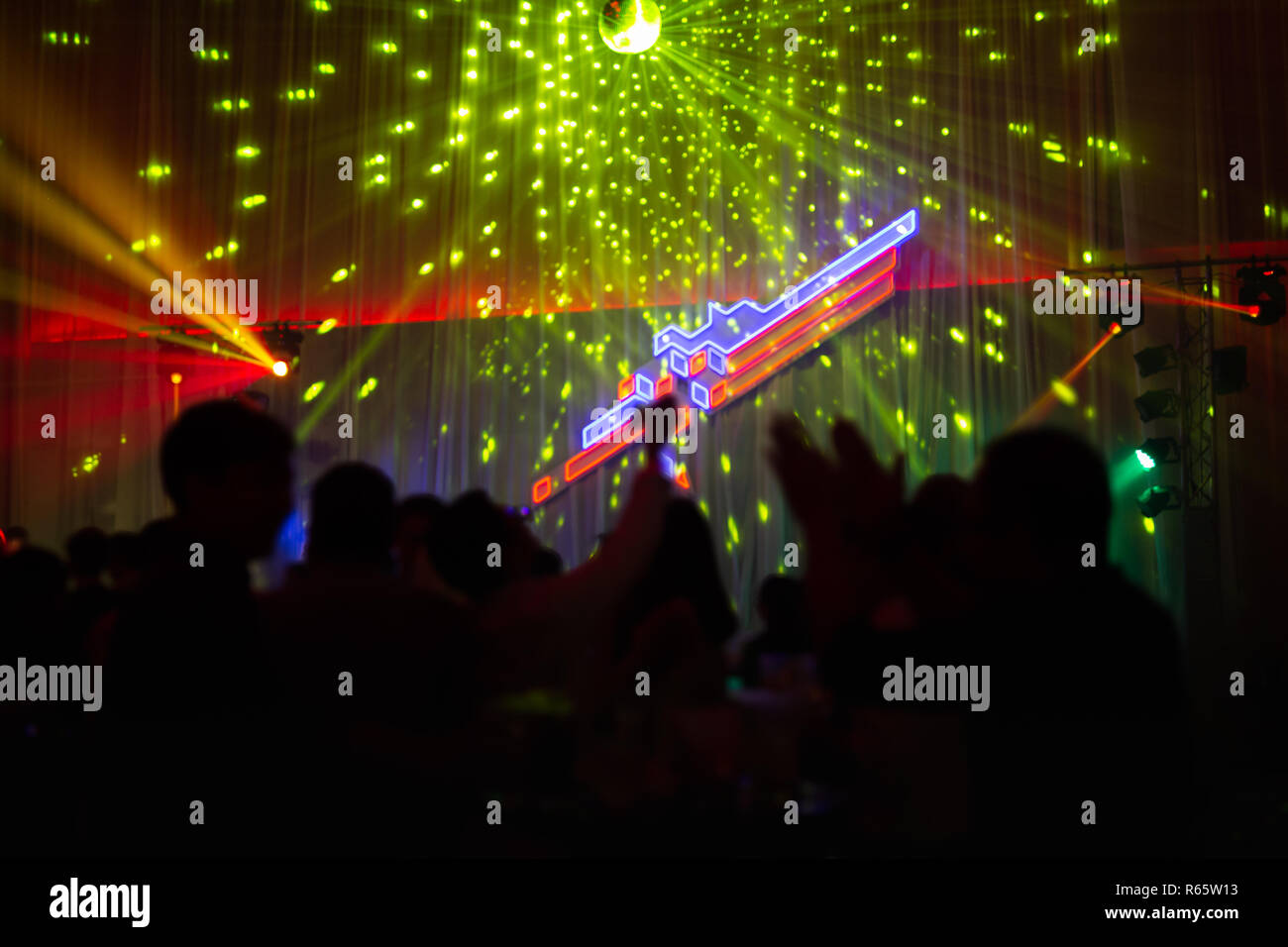 Blurred concept at concert party with audience and colourful led ...