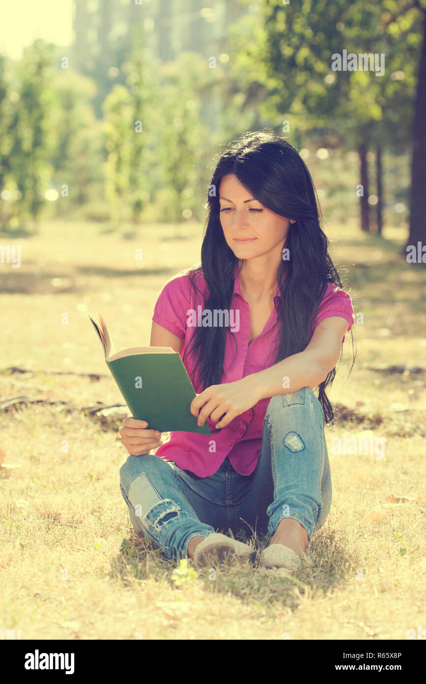 Woman reading book outdoor Stock Photo - Alamy