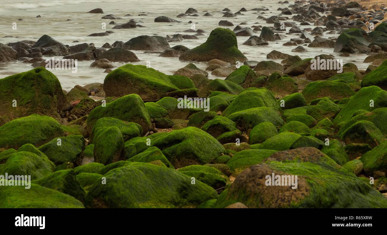 A rocky outcrop coastal defence barrier made of tetrapods and large ...