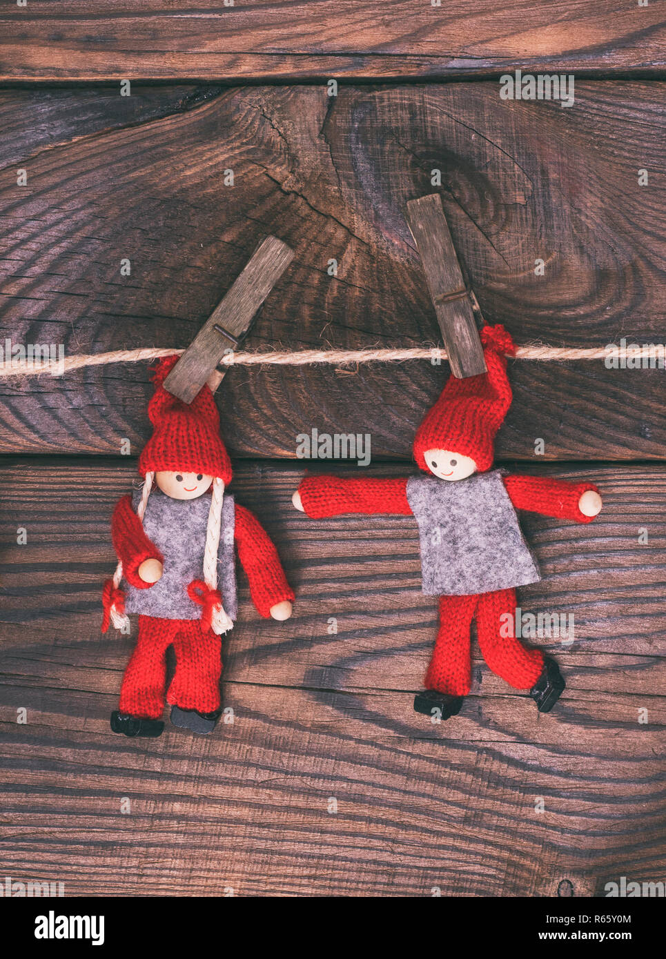 two wooden dolls hang on a rope Stock Photo - Alamy