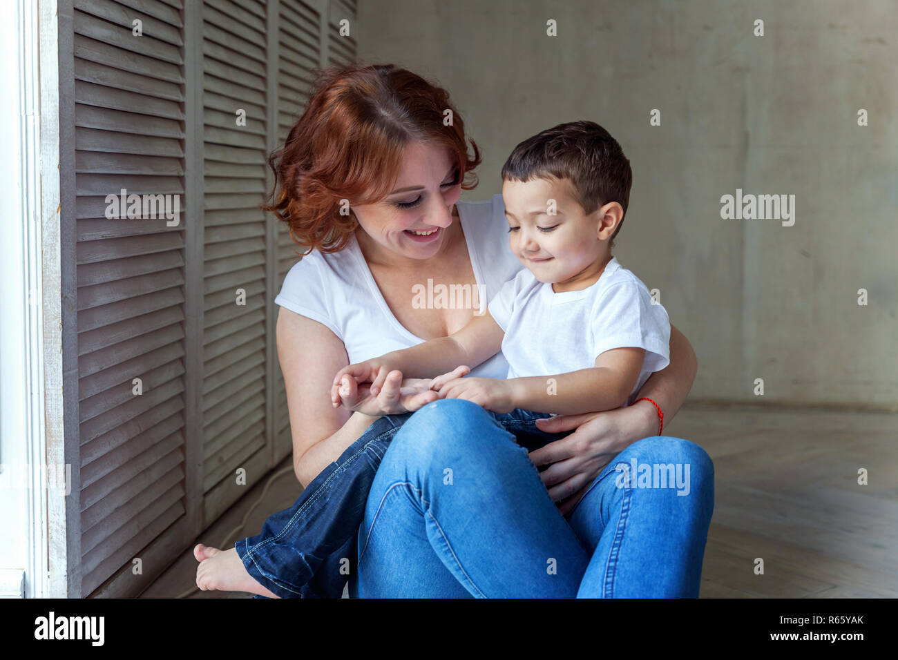 Young mother holding her child. Woman and little boy relax in a bright ...