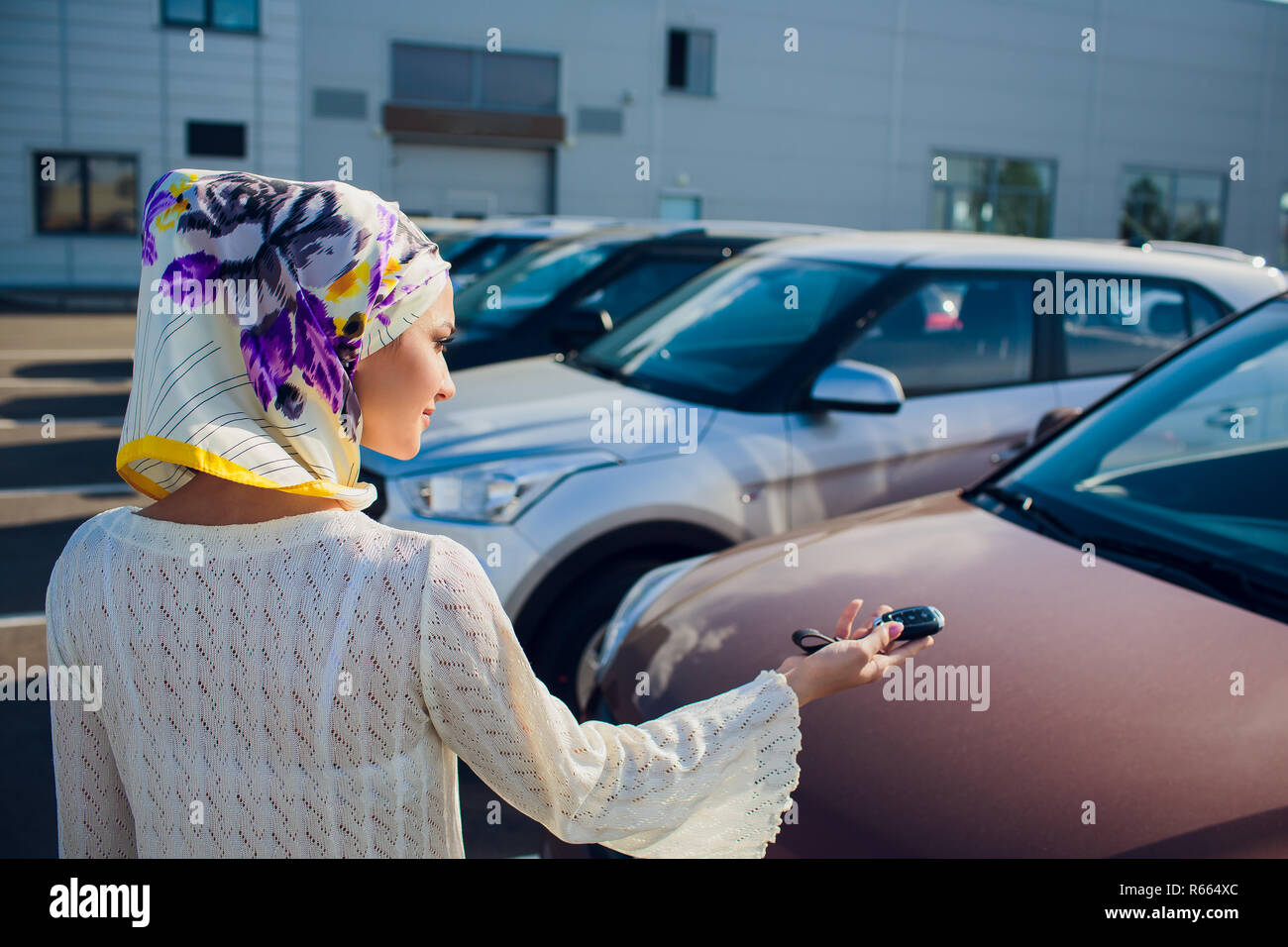 property and people concept - muslim woman in hijab with car key over ...