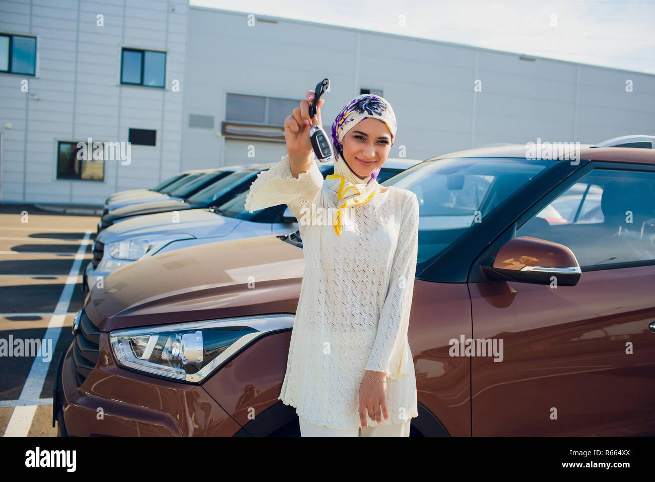 property and people concept - muslim woman in hijab with car key over ...